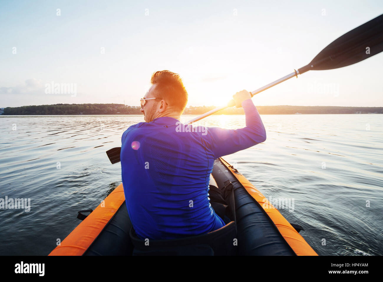 man floating on lake in a kayak at fantastic sunset Stock Photo - Alamy