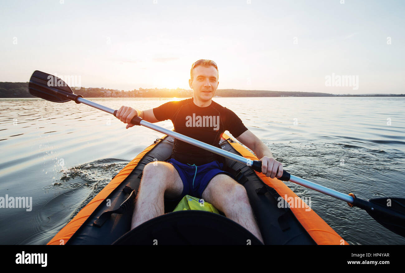 man floating on lake in a kayak at fantastic sunset Stock Photo - Alamy