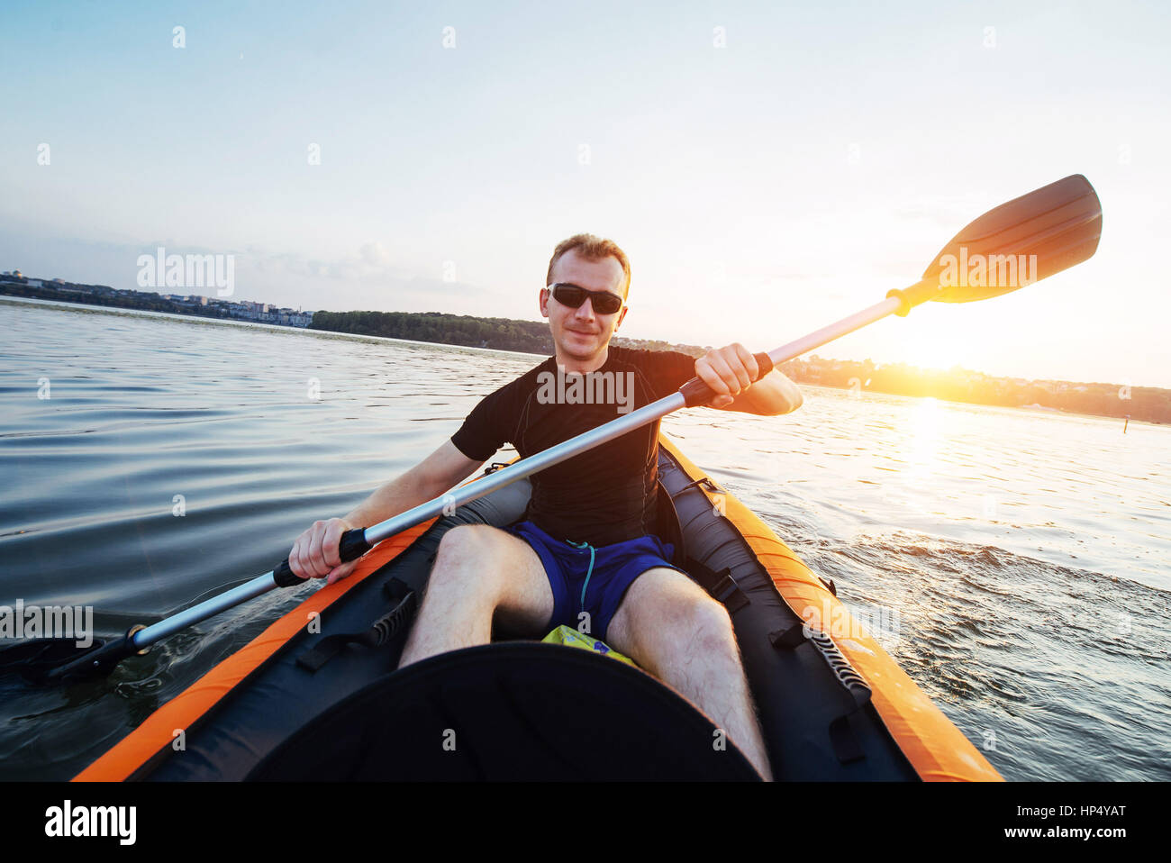 man floating on lake in a kayak at fantastic sunset Stock Photo - Alamy