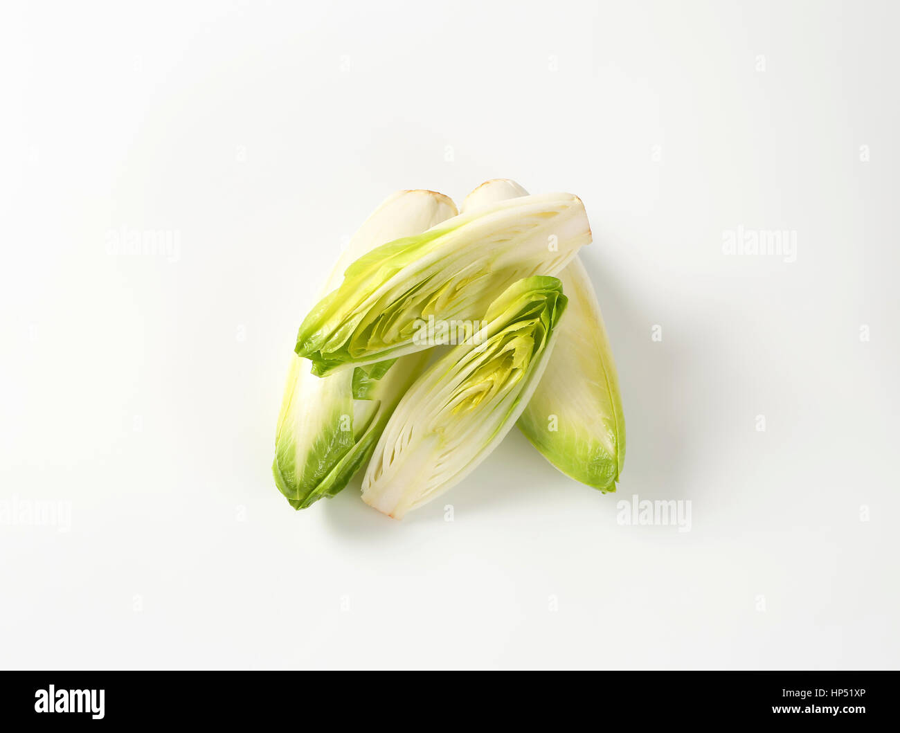 whole and halved heads of fresh belgian endive Stock Photo - Alamy