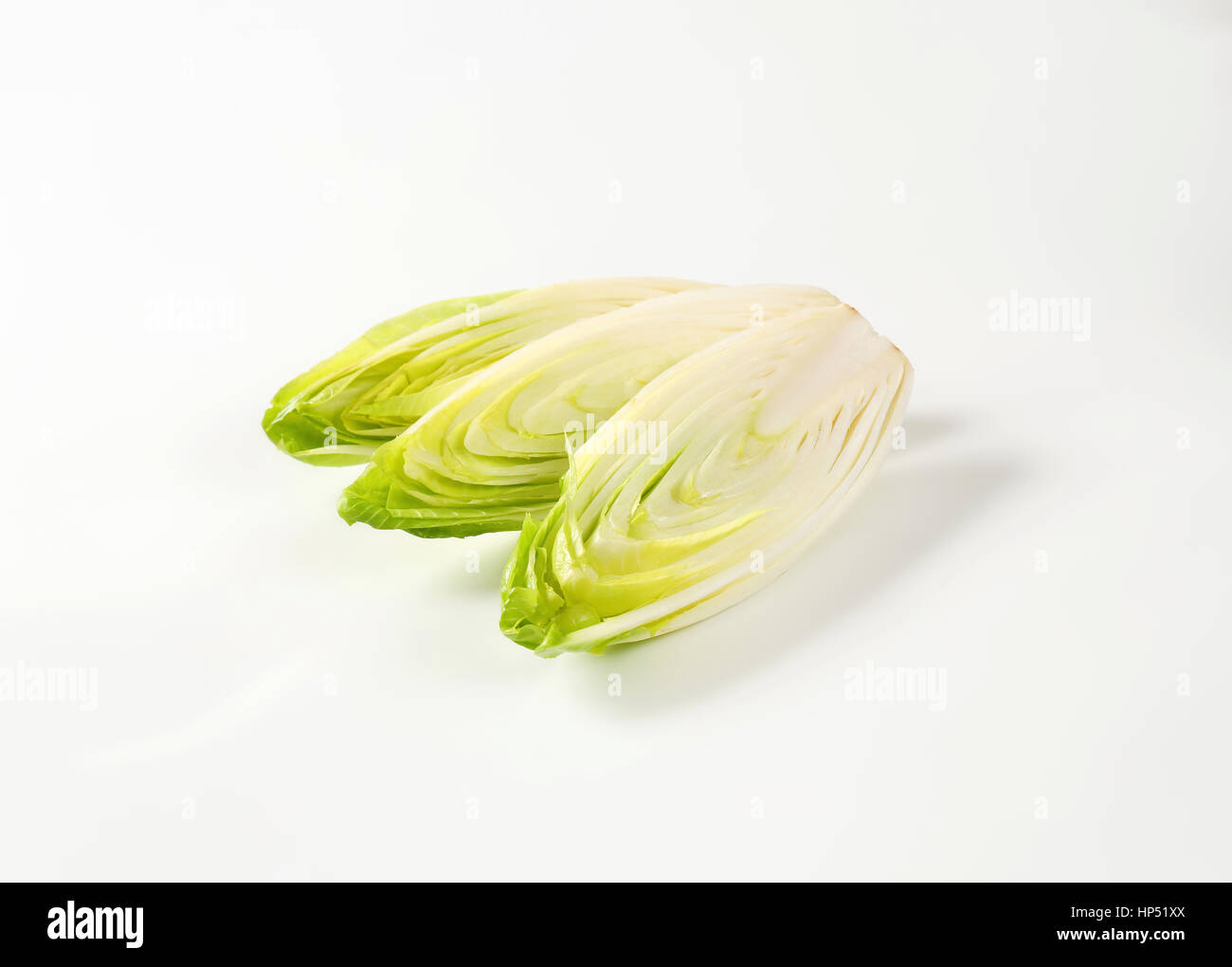 halved heads of fresh belgian endive on white background Stock Photo ...