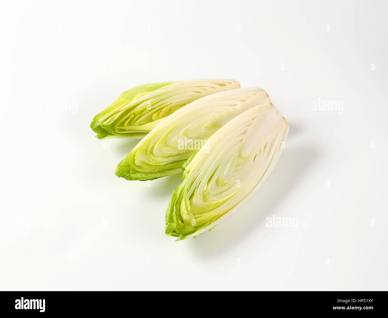 halved heads of fresh belgian endive on white background Stock Photo ...