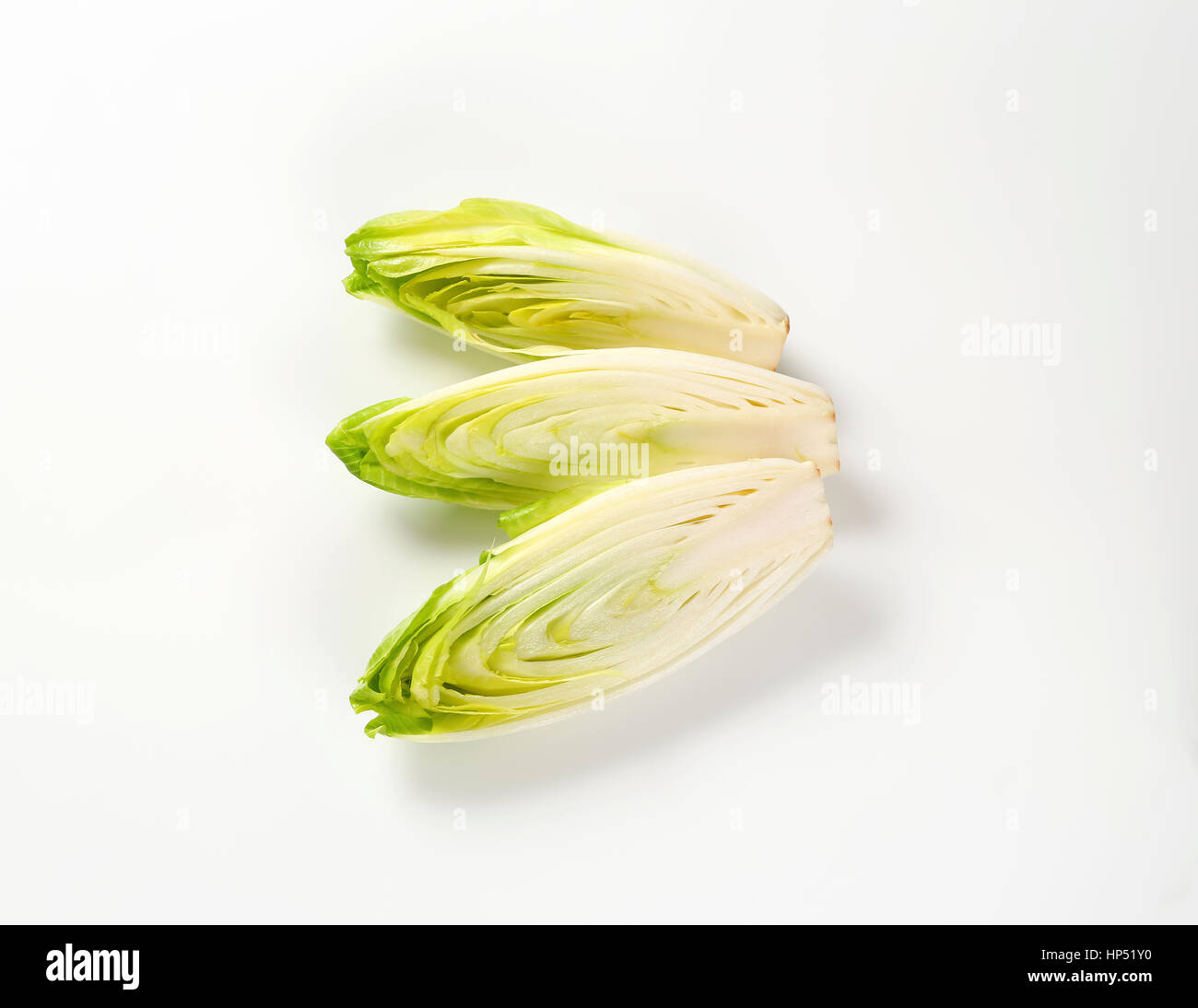 halved heads of fresh belgian endive on white background Stock Photo ...