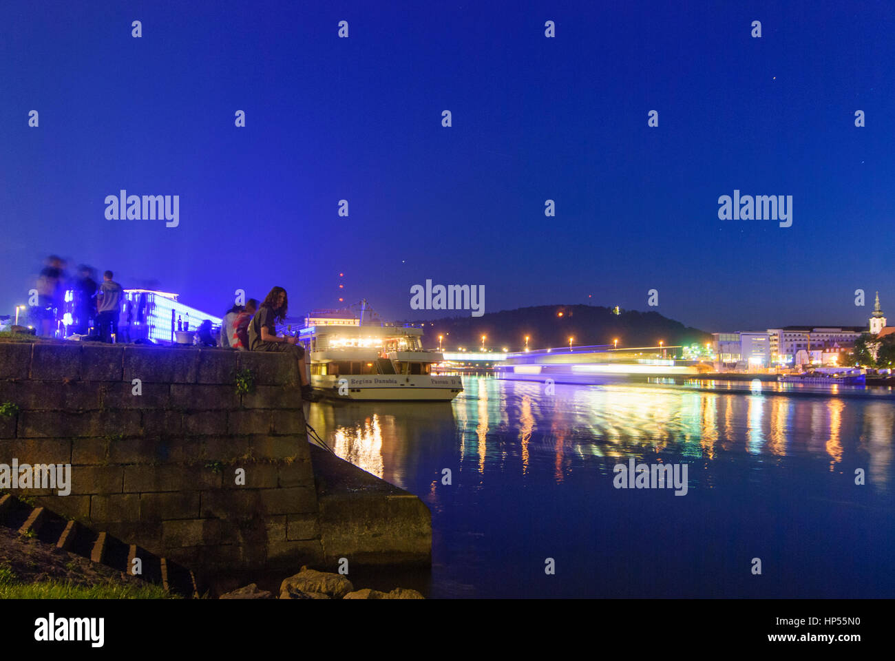 Linz, Danube with art museum Lentos and young people at the evening ...