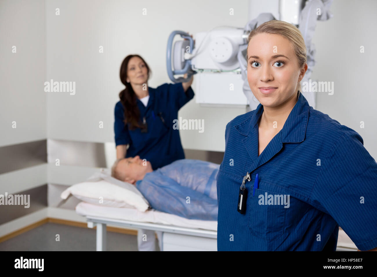 Young Radiologist Standing While Colleague Taking Patient's Xray Stock ...