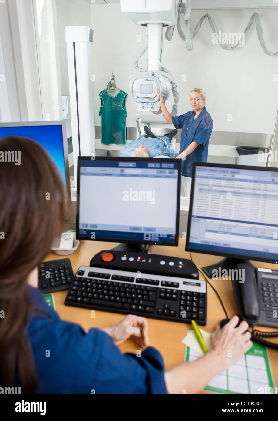 Doctor Taking Patient's Xray While Coworker Using Computer At De Stock ...
