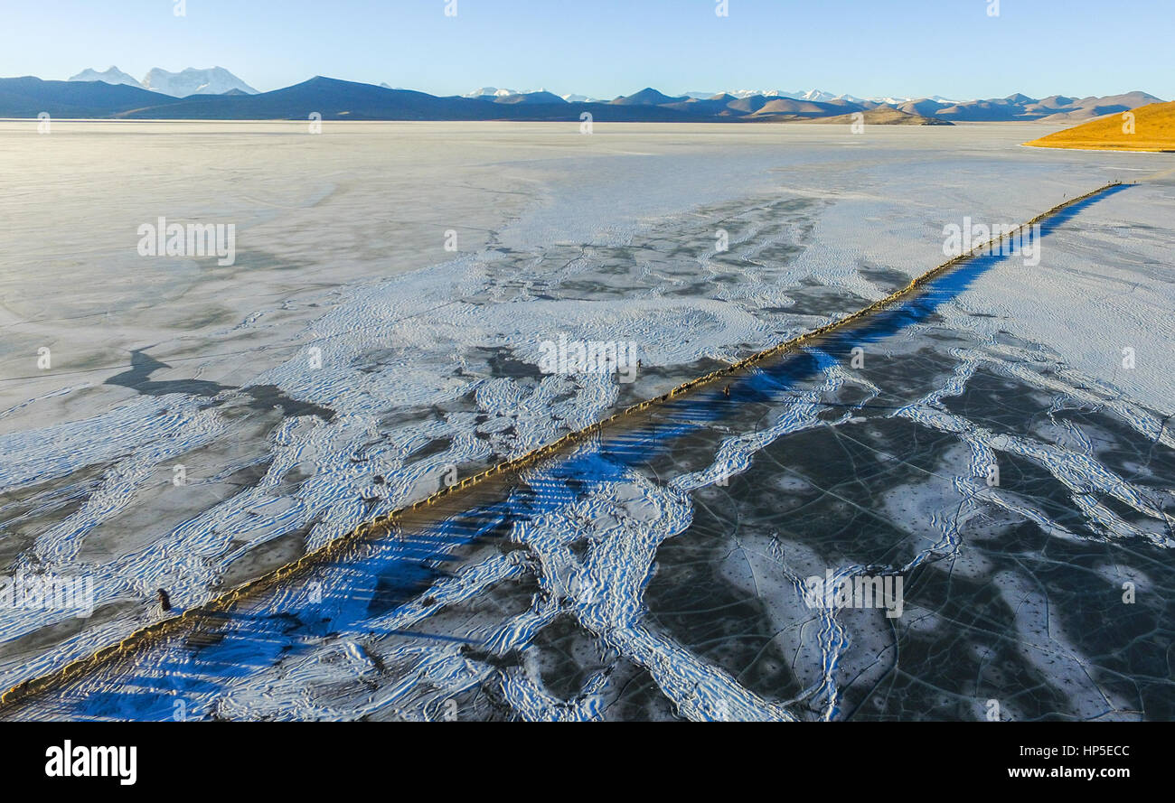 Villagers lead a herd of sheep on the frozen Puma Yumco Lake, southwest ...