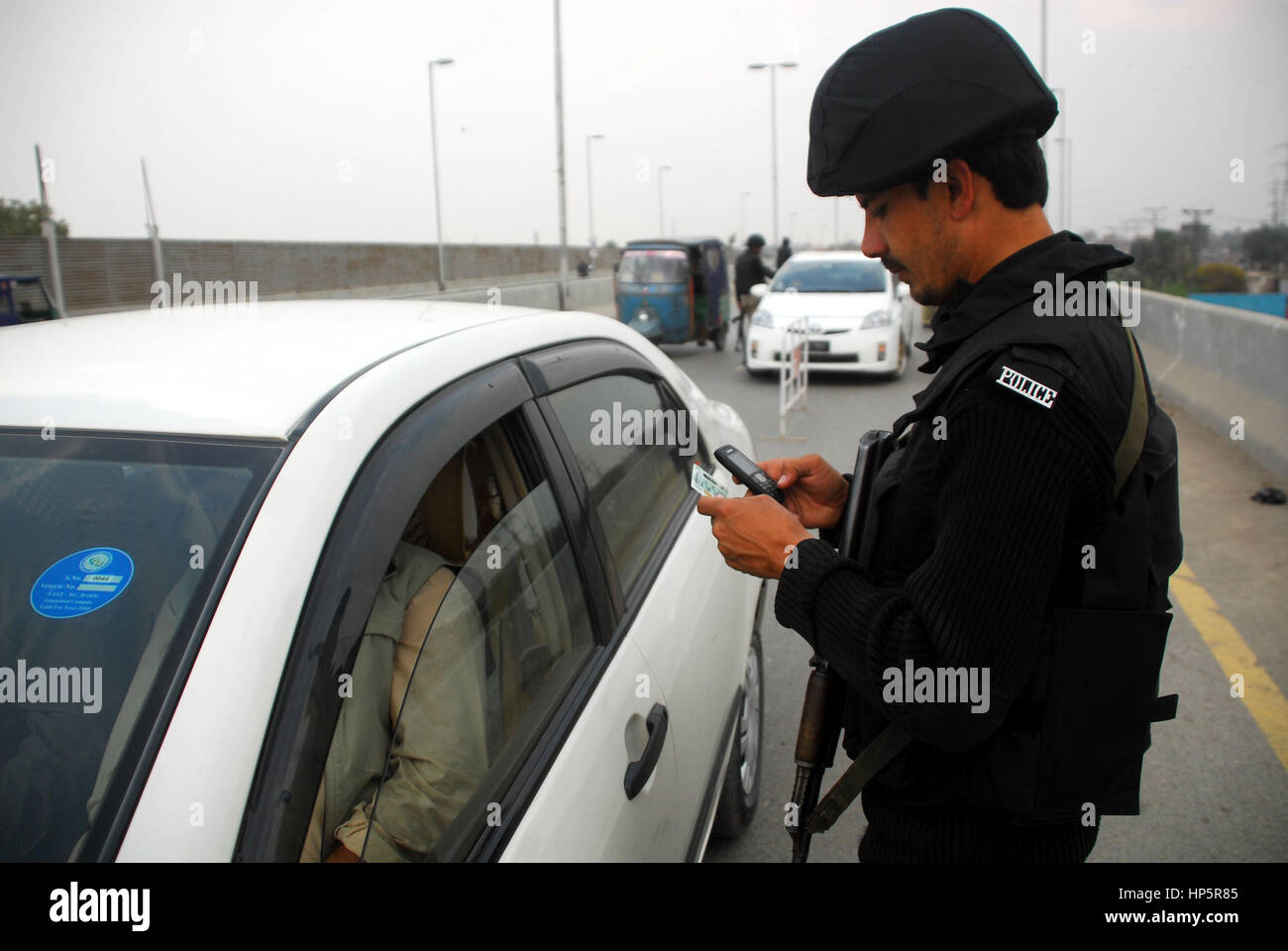 Peshawar. 19th Feb, 2017. A Pakistani policeman checks identity card of ...