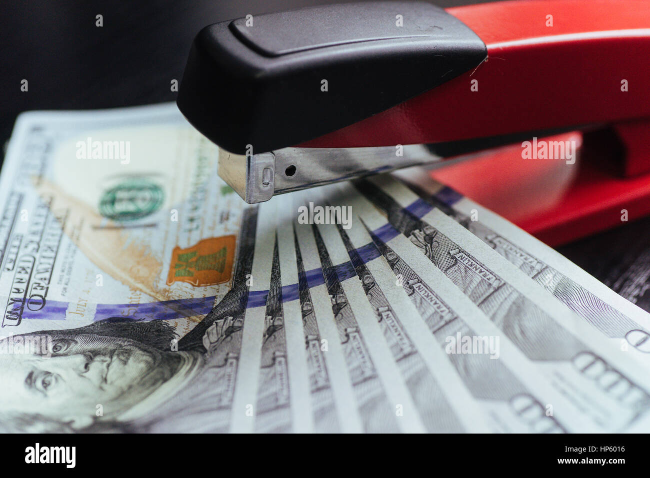 dollars and stapler on a black background Stock Photo - Alamy