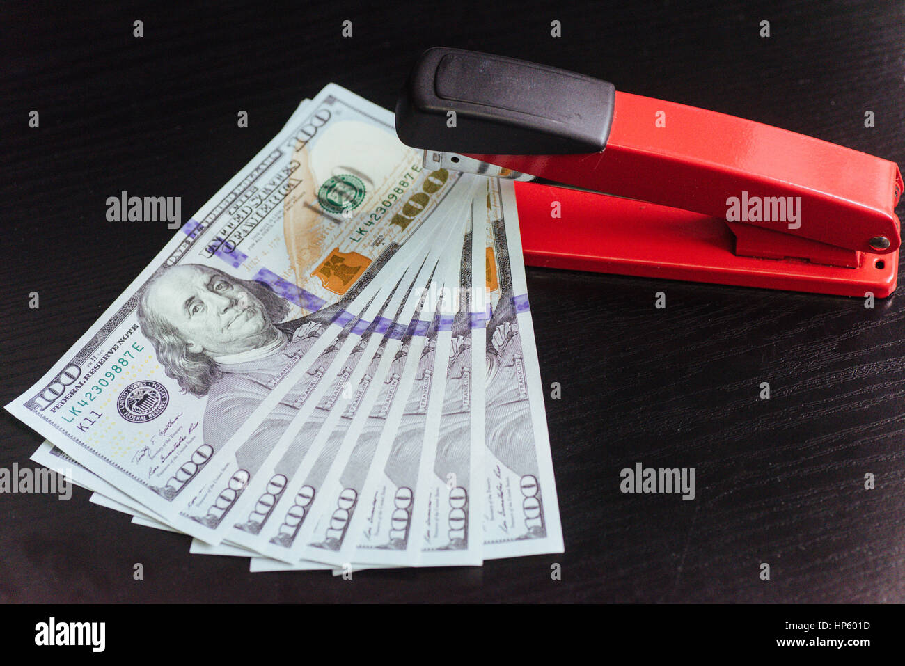 dollars and stapler on a black background Stock Photo - Alamy