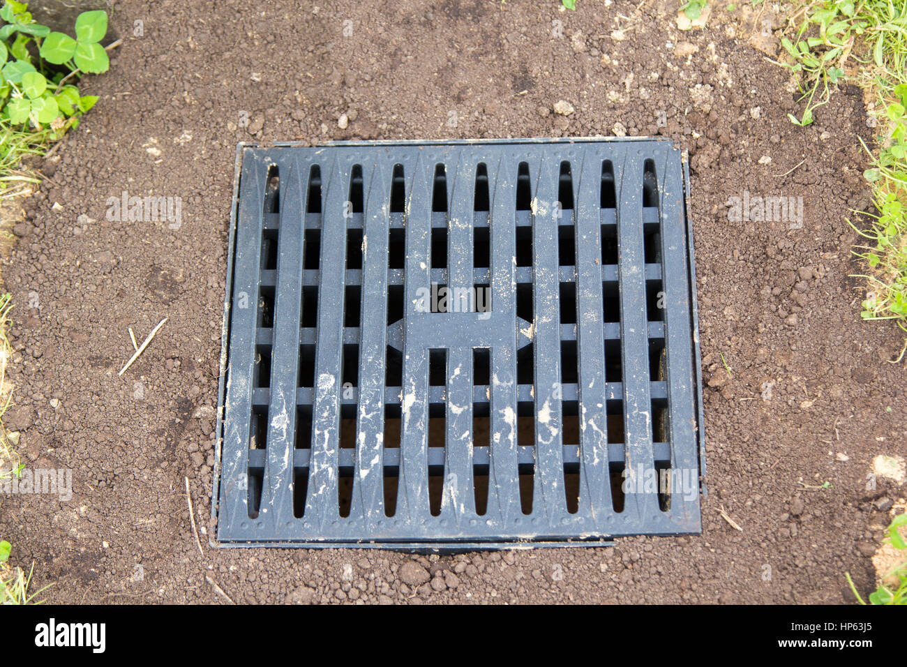 Cover of the water drain hatch in the ground Stock Photo - Alamy