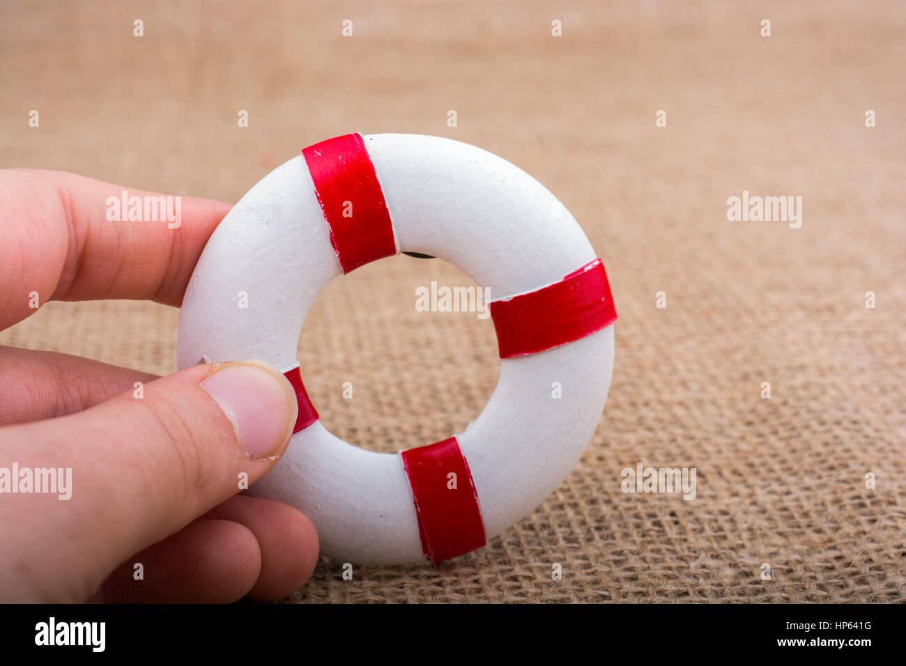 Hand holding a Lifesaver or life preserver on a fabric background Stock ...