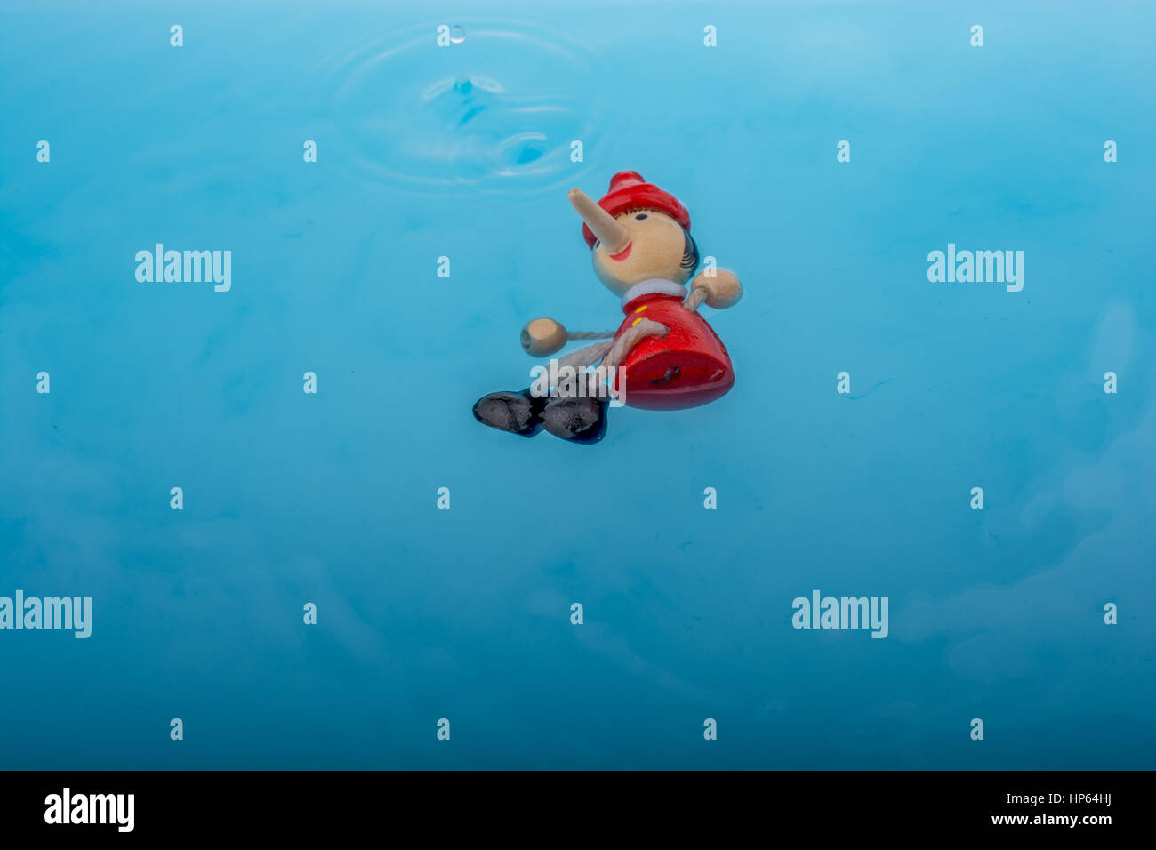 Wodden puppet Pinocchio on in blue water Stock Photo - Alamy
