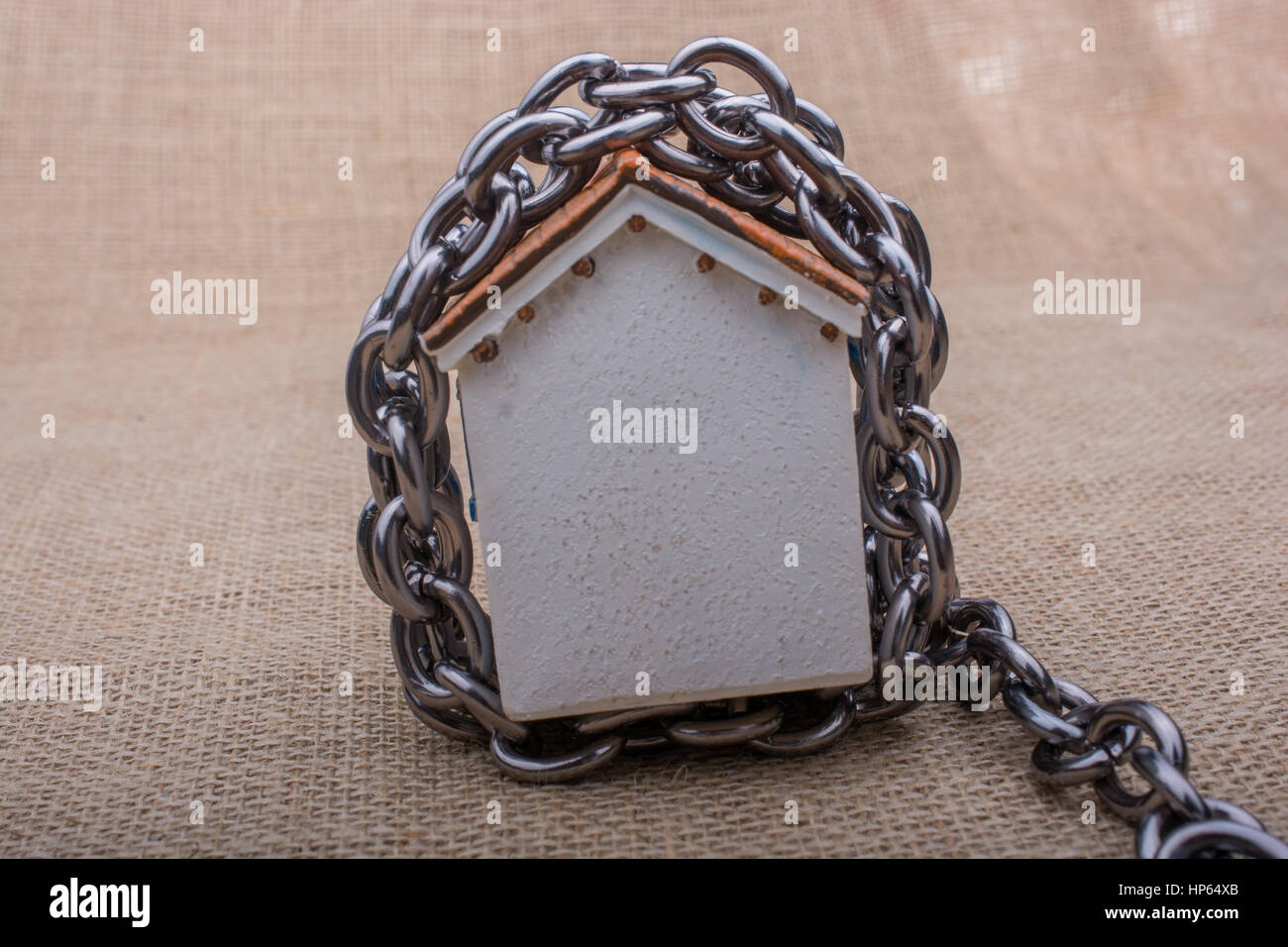 Chain wrapped around a model house on a brown background Stock Photo ...