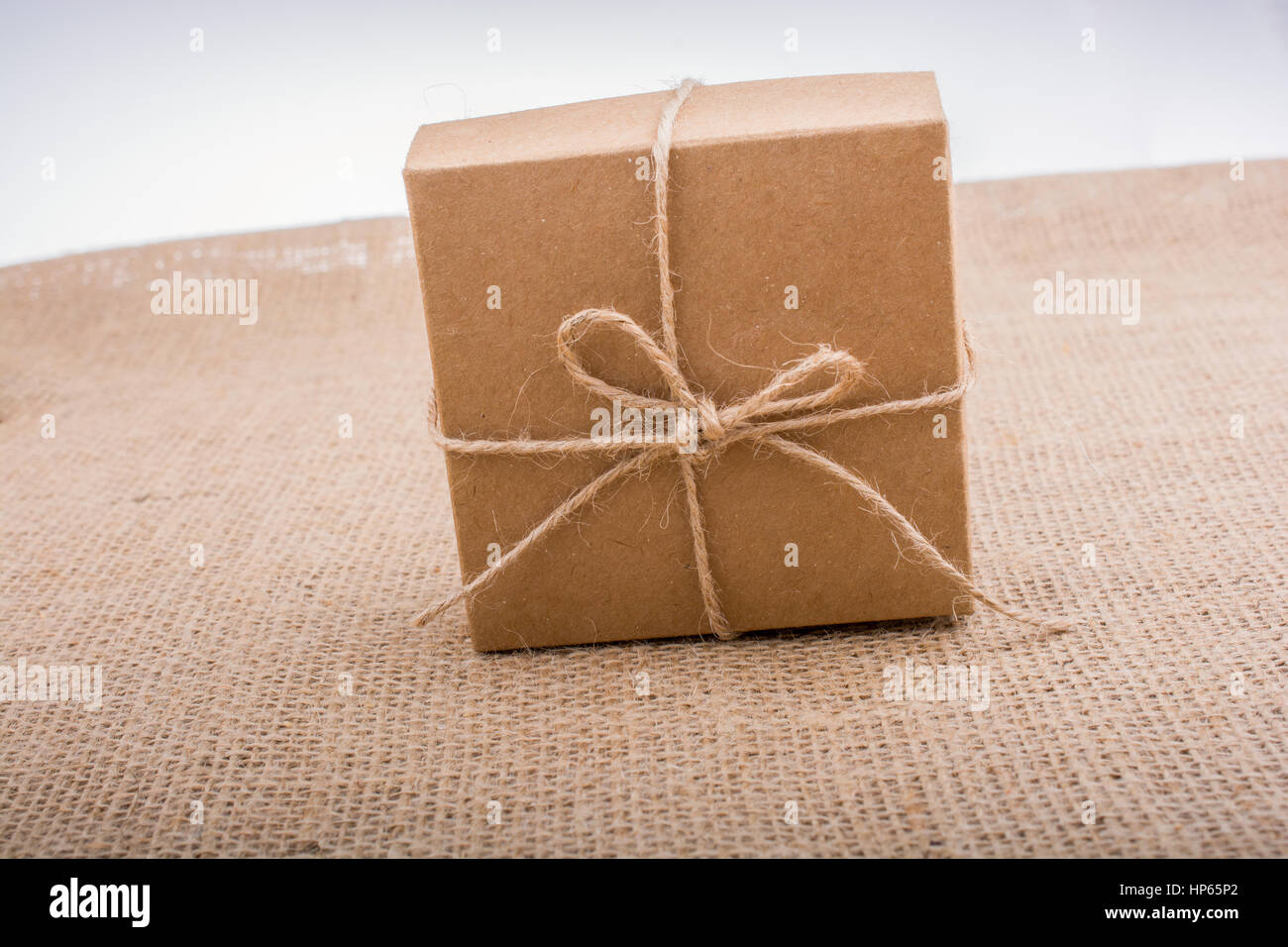 Gift box of brown color on linen canvas Stock Photo - Alamy