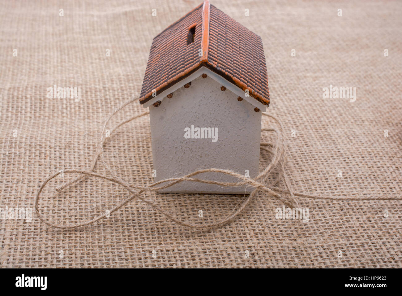 Thread wrapped around a model house on a brown background Stock Photo ...