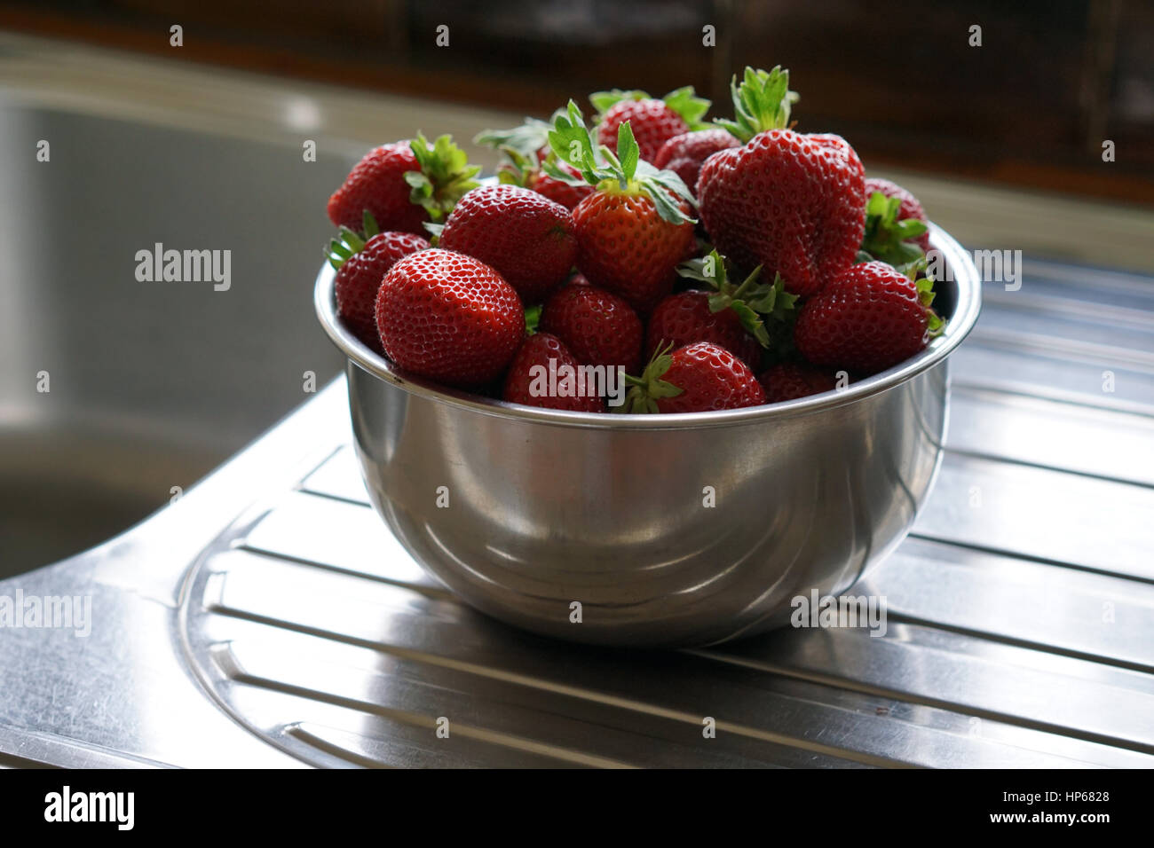A bowl of strawberries on the kitchen bench Stock Photo - Alamy