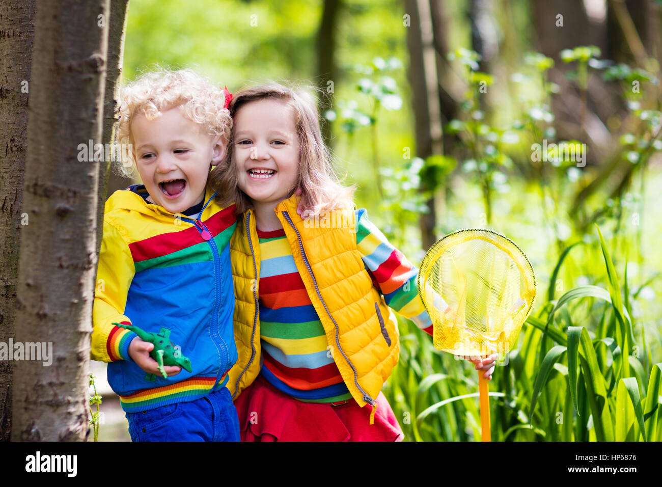 Children playing outdoors. Preschool kids catching frog with net. Boy ...