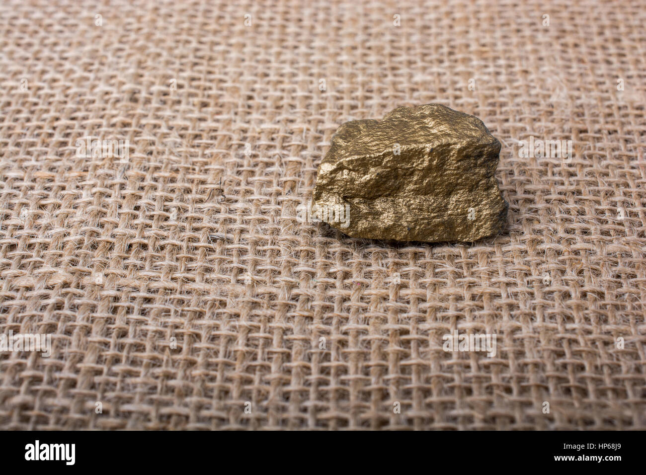 little gold color stone on a linen canvas Stock Photo - Alamy