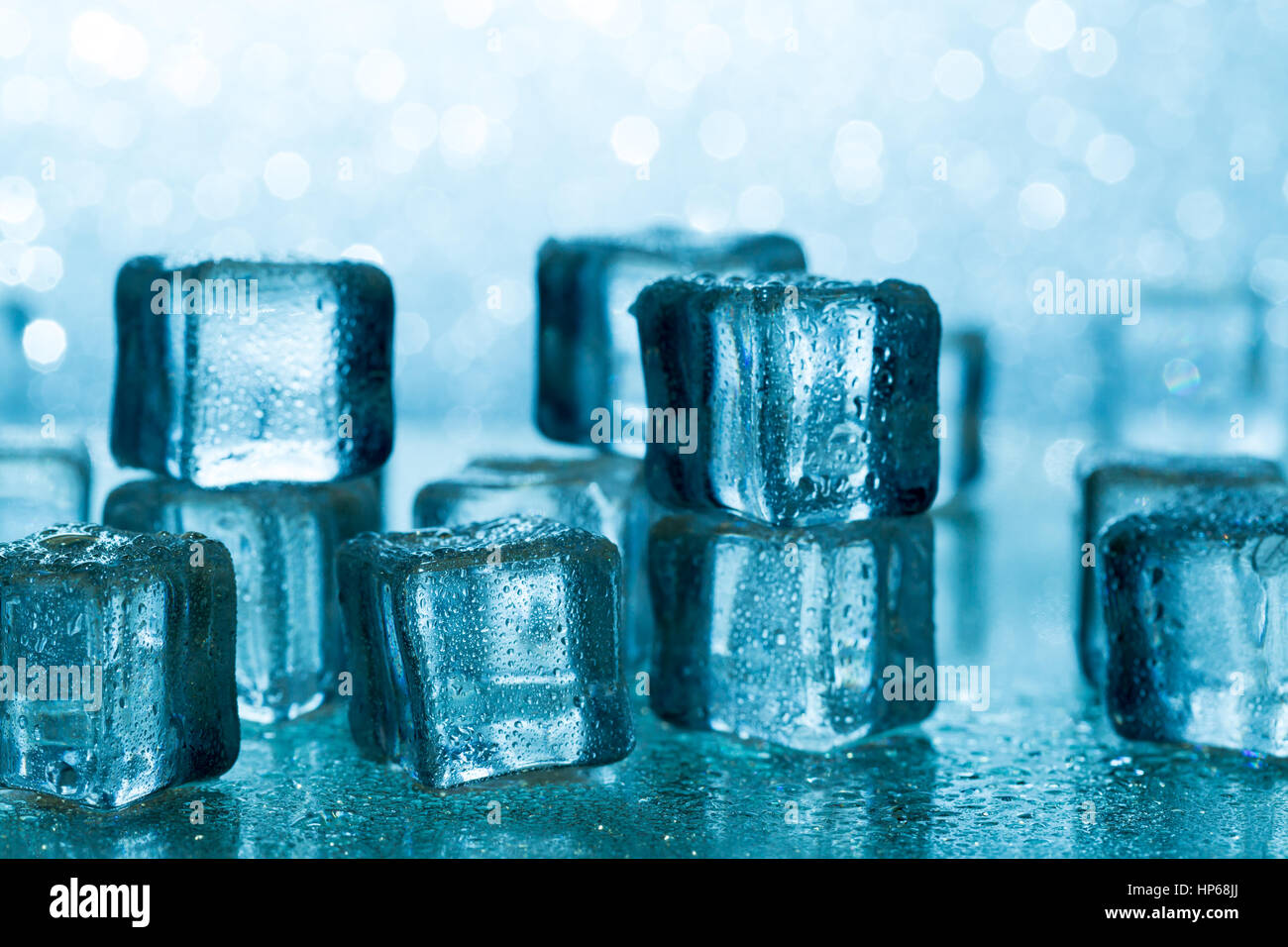 Group of melting ice cubes on glass table Stock Photo - Alamy