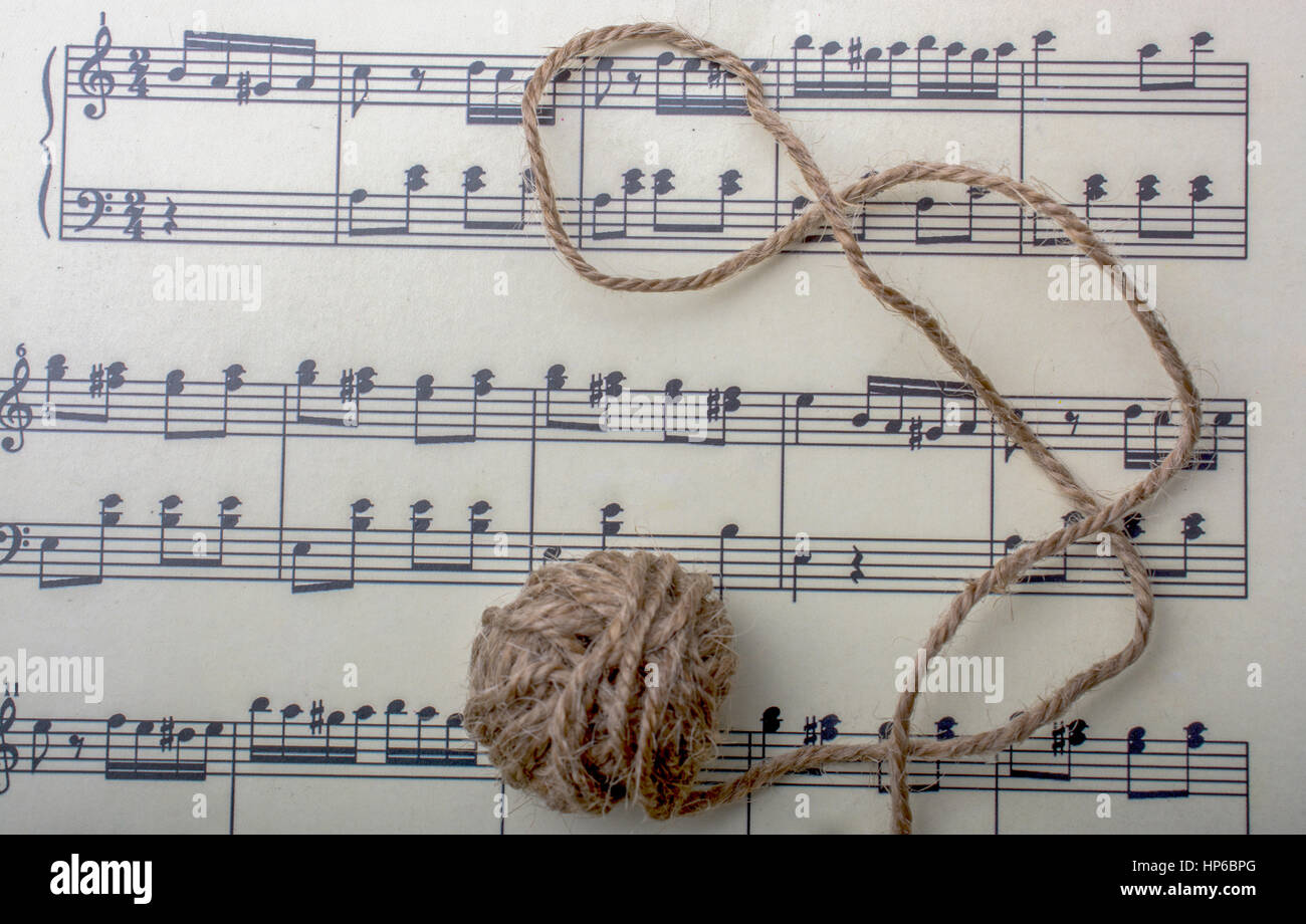 linen thread is placed on paper with musical notes Stock Photo - Alamy