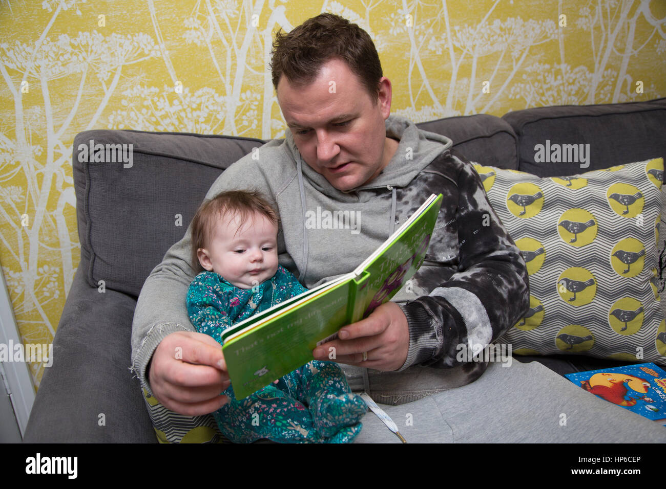 Dad reading to baby Stock Photo - Alamy