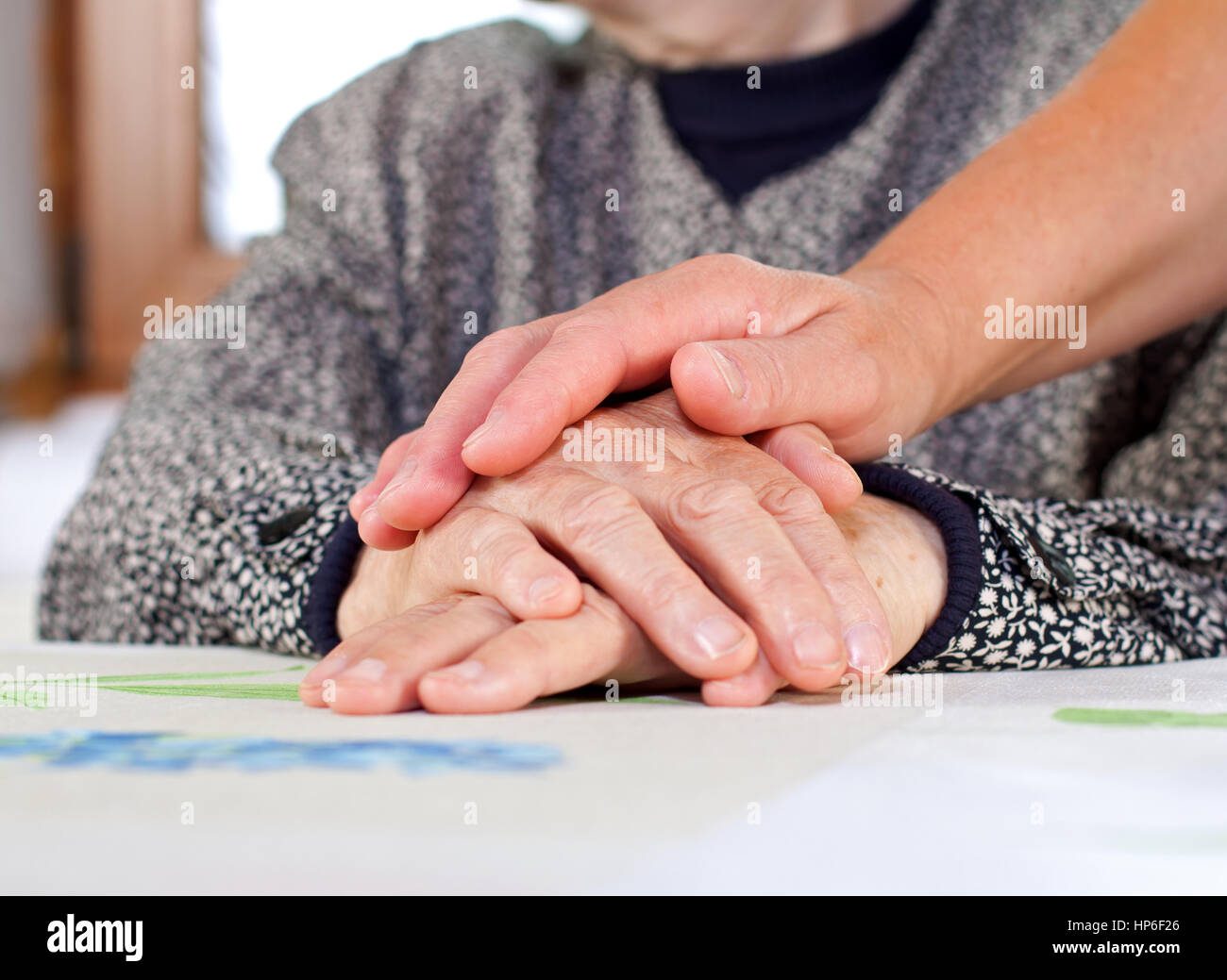 Doctor's hand holding a wrinkled elderly hand Stock Photo - Alamy