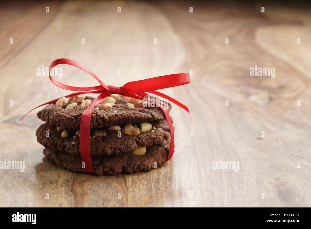 stack of homemade chocolate cookies with hazelnuts tied with ribbon on ...