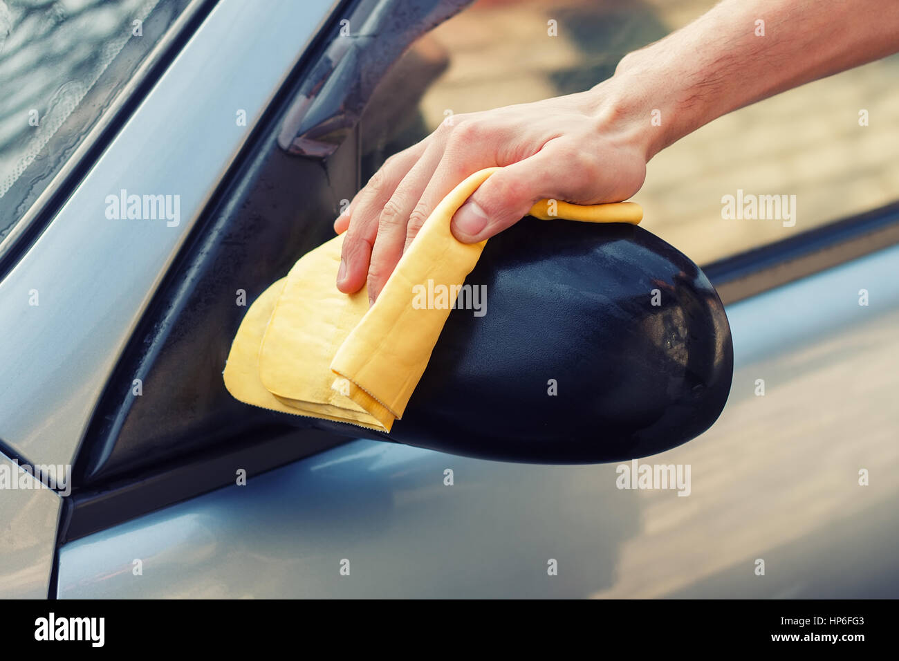 waterless car wash. Men's hand with yellow cloth cleaning car photo ...