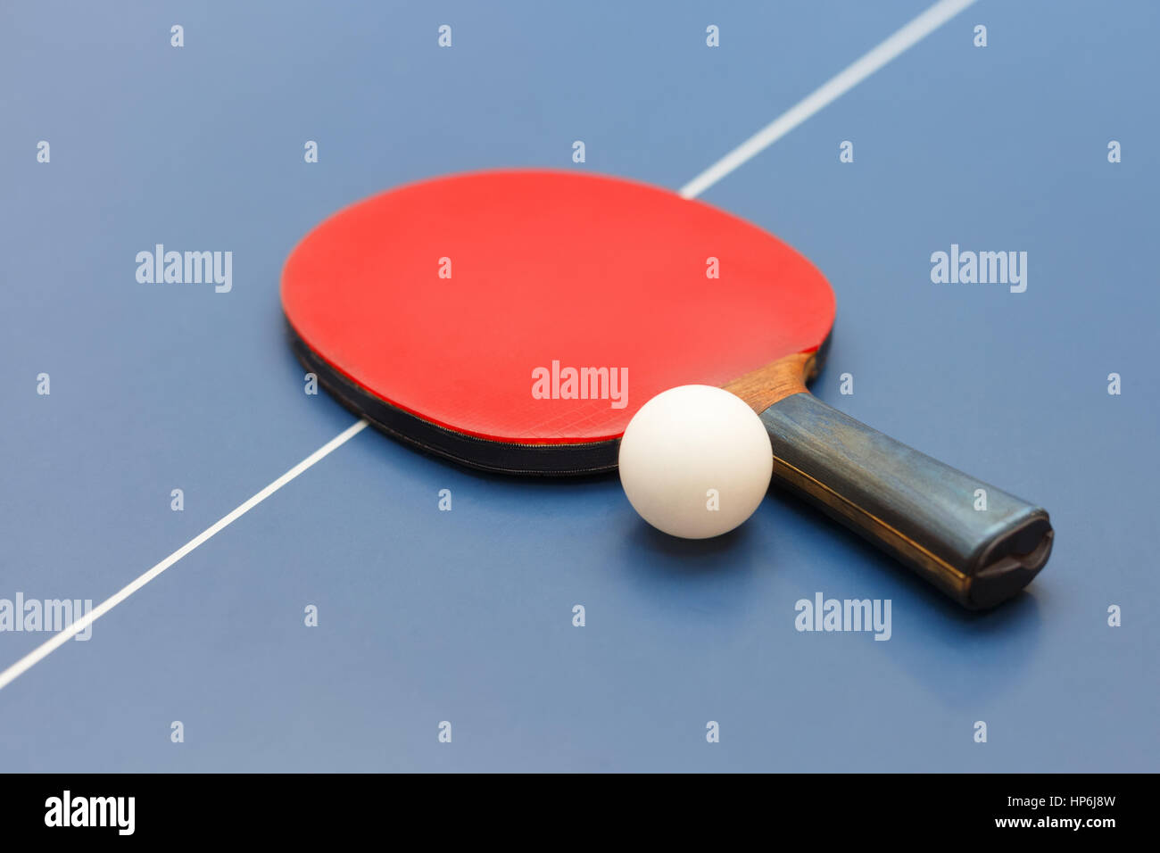 Table tennis red racket and white ball on blue board. Equipment for ...