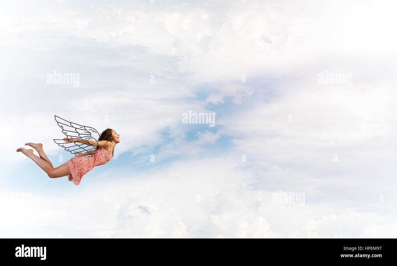 Young woman flying high in blue sky Stock Photo - Alamy