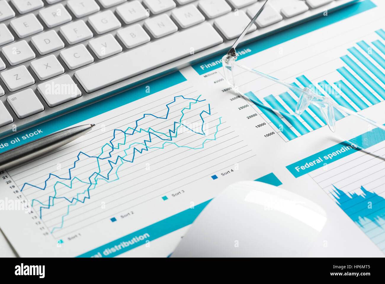 Business workplace with keyboard mouse and papers with graphs and ...