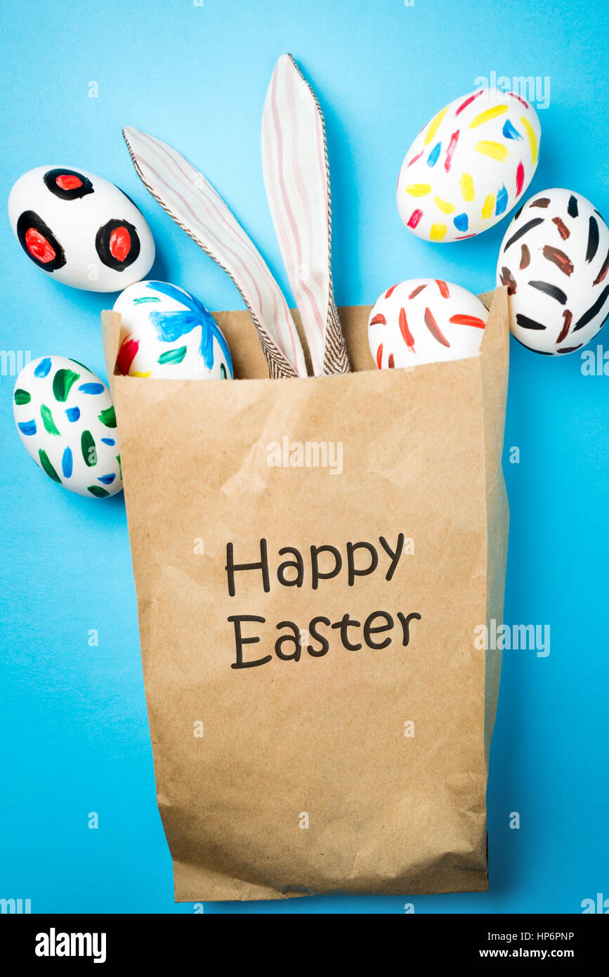 Easter bunny in a paper bag. Blue background. Easter ideas. Easter eggs ...