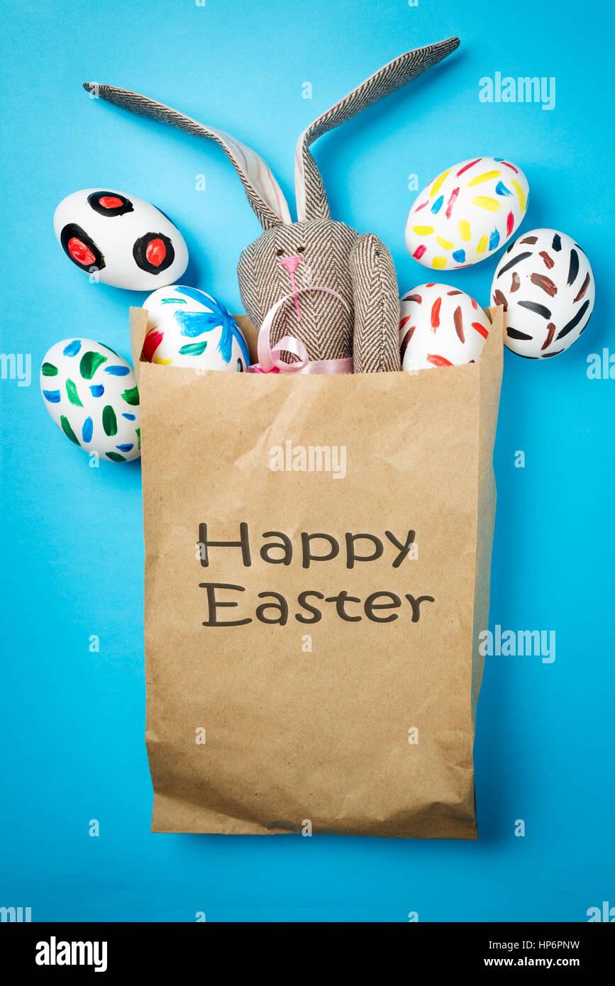 Easter bunny in a paper bag. Blue background. Easter ideas. Easter eggs ...