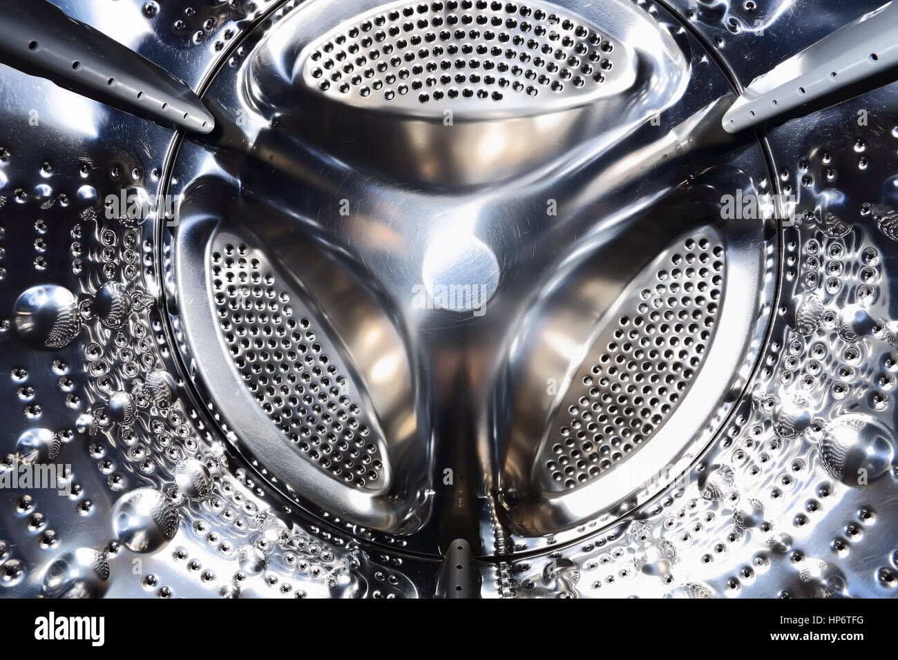 Washing machine drum closeup. Shiny steel background. Steel with holes ...