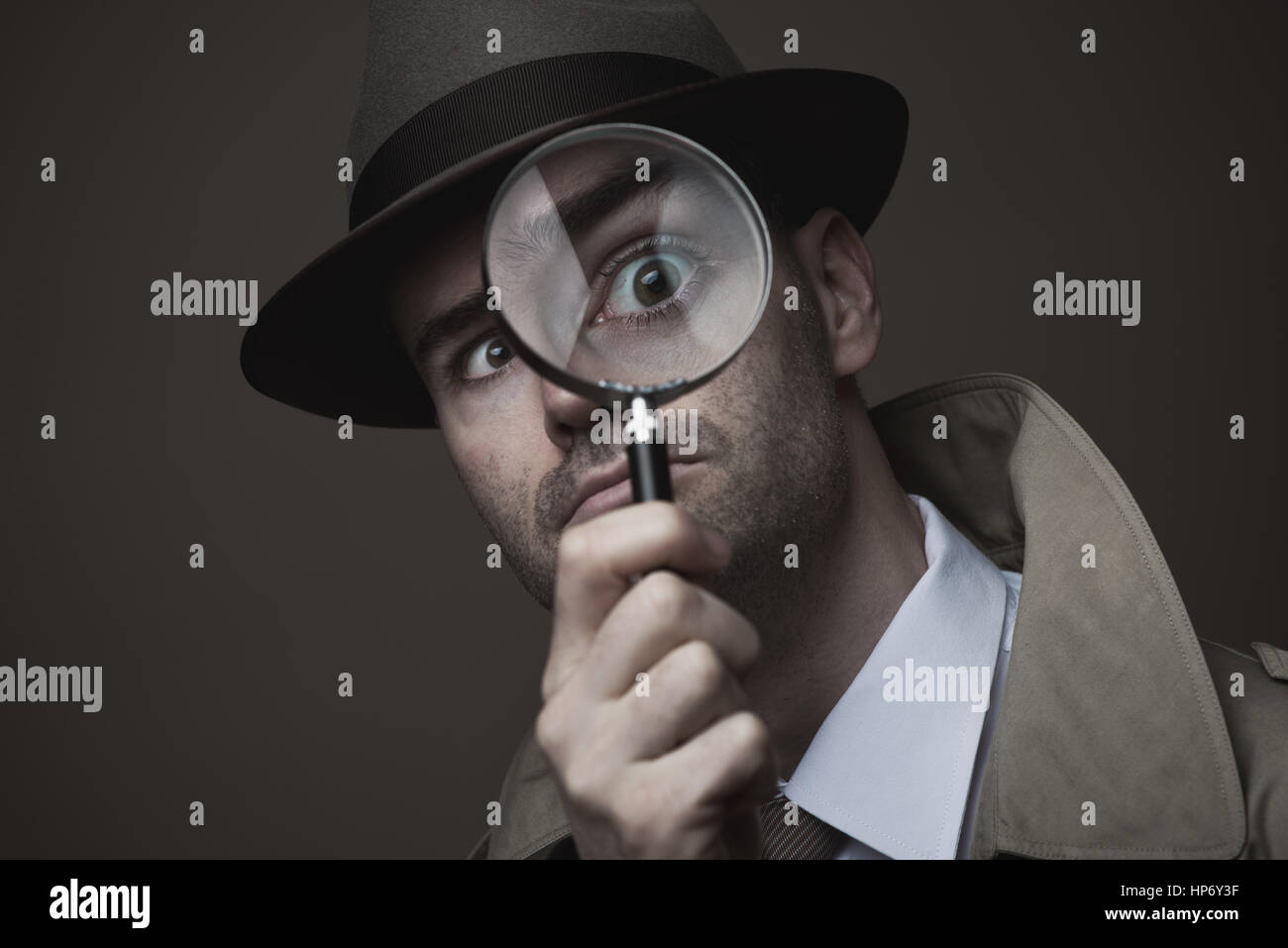 Funny vintage detective looking through a magnifier Stock Photo - Alamy