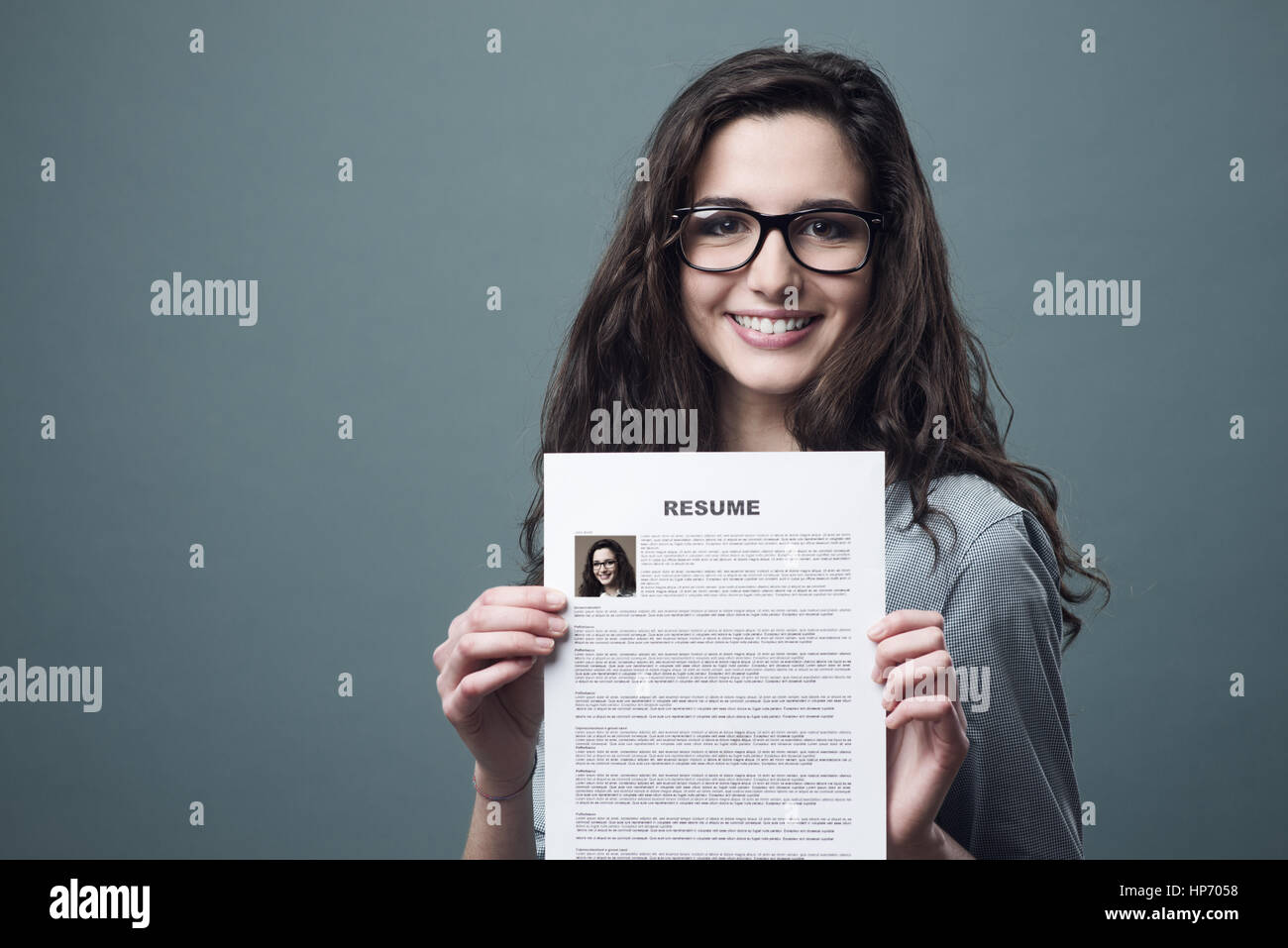 Young smiling cheerful woman holding her resume Stock Photo - Alamy