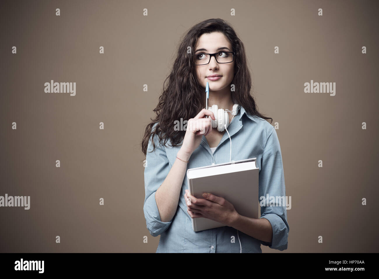 Cute student girl taking notes with a pen and smiling Stock Photo - Alamy