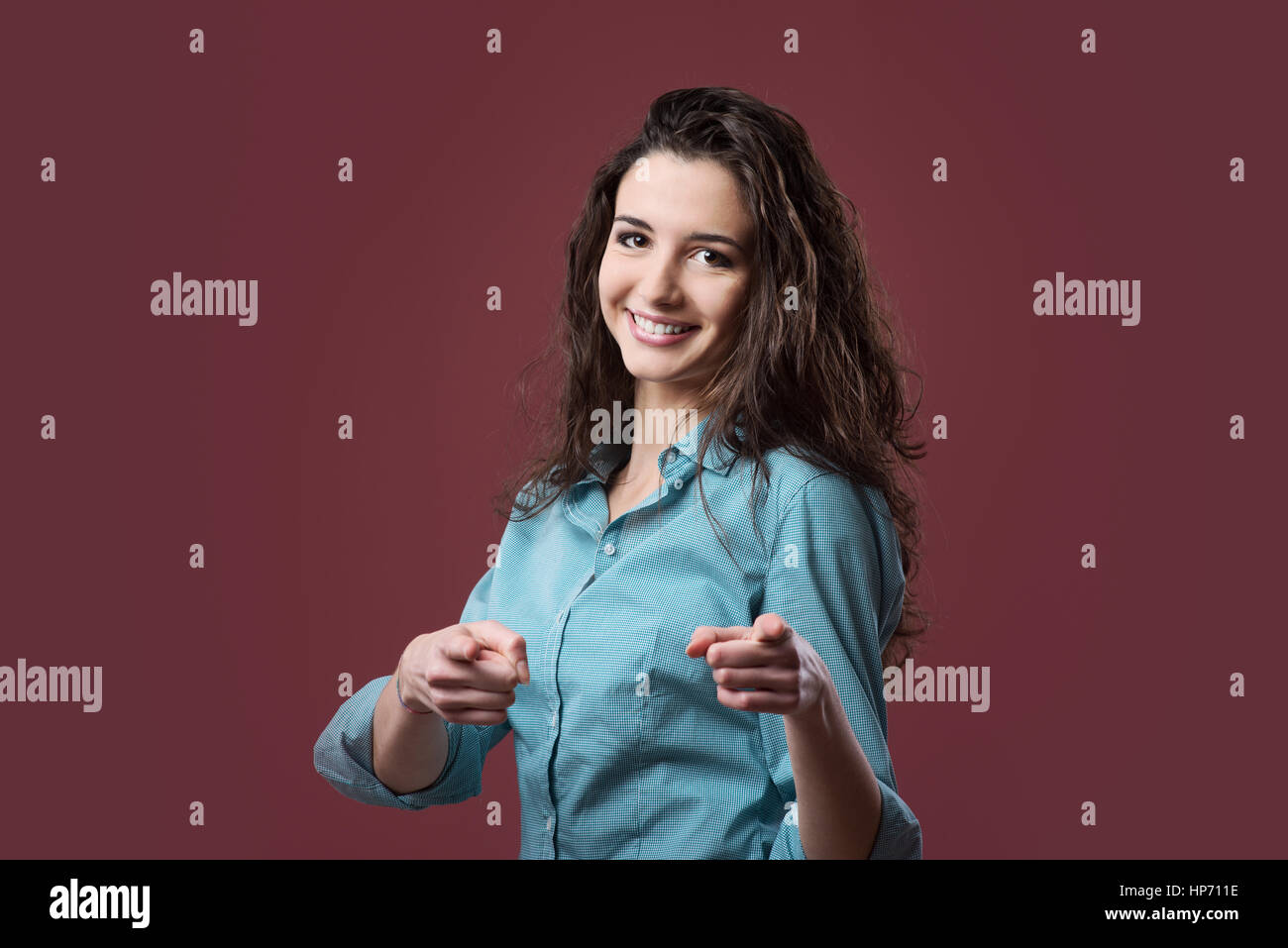 Cheerful smiling young woman pointing forward Stock Photo - Alamy