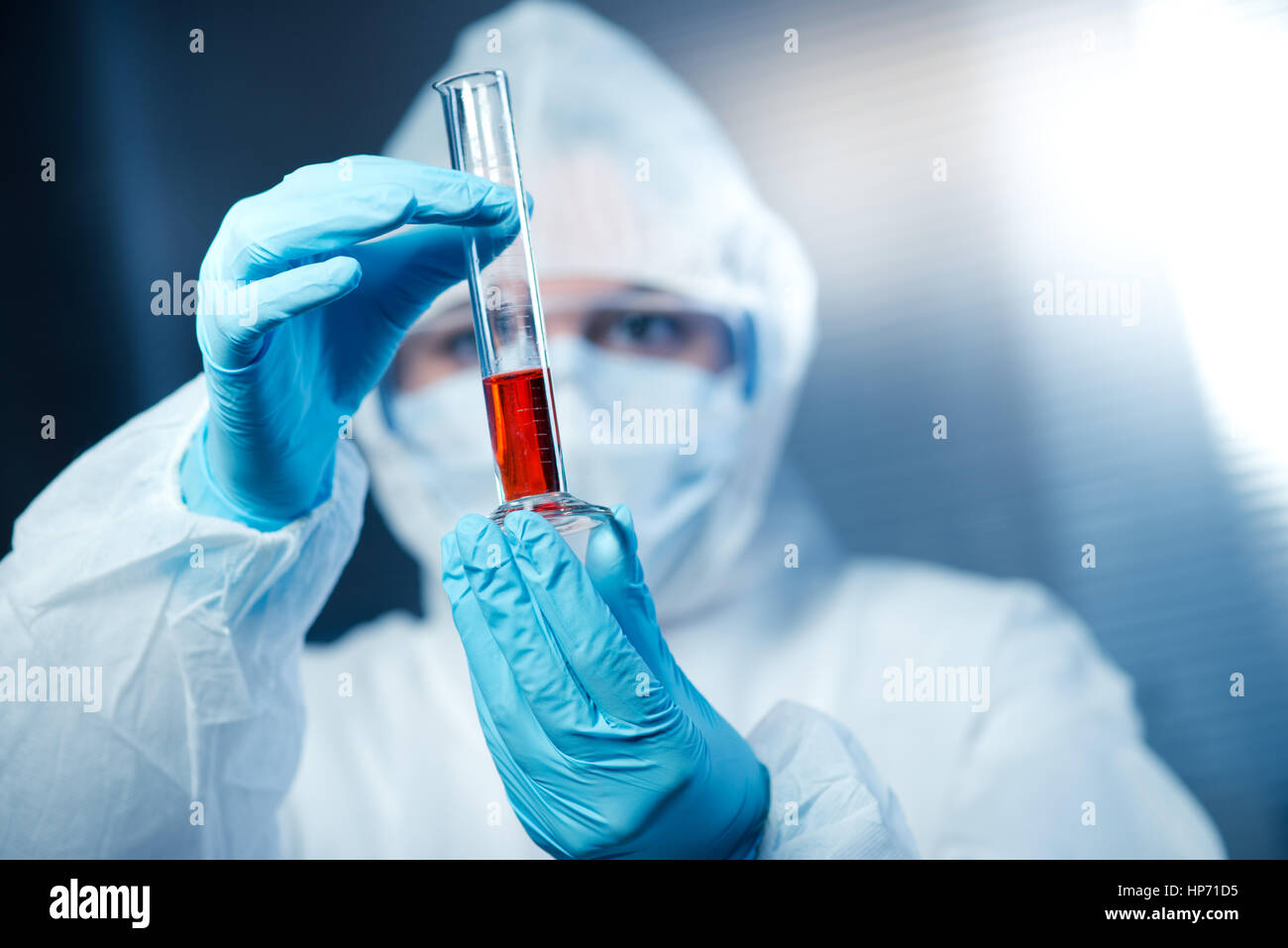 Scientist wearing protective suit and examining a test tube Stock Photo ...