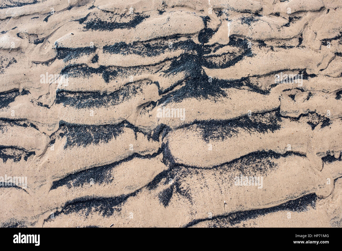 Sand and black sea coal on Saltburn beach, showing wave patterns Stock ...