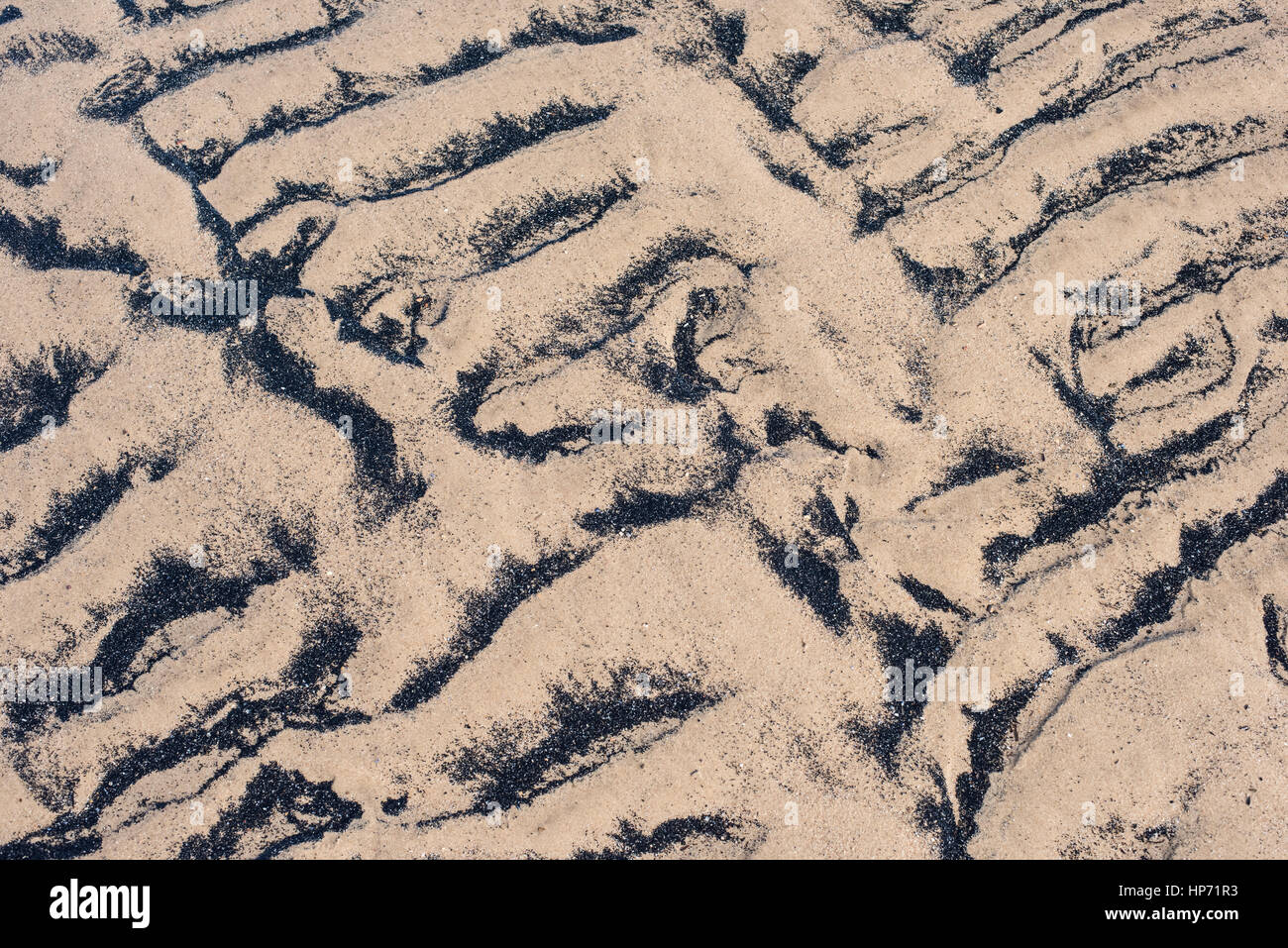 Sand and black sea coal on Saltburn beach, showing wave patterns Stock ...