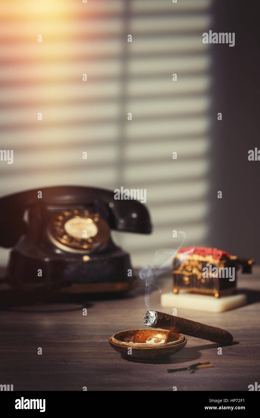 Lit cigar smoking in an ashtray. Antique vesta box and vintage ...