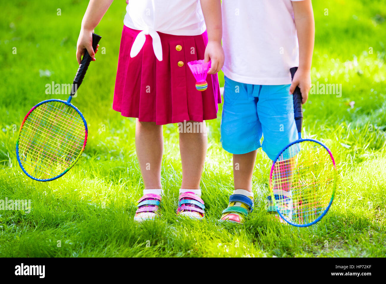 Active preschool girl and boy playing badminton in outdoor court in ...