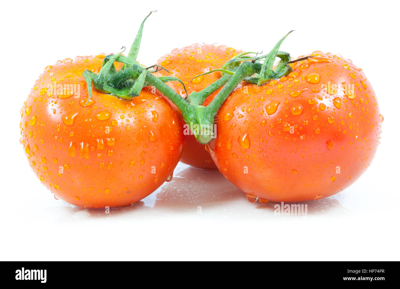 Three tomato with drops on white background Stock Photo - Alamy