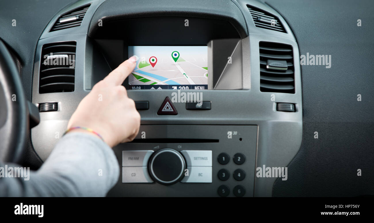 Female finger touching a touch screen navigation panel on car dashboard ...