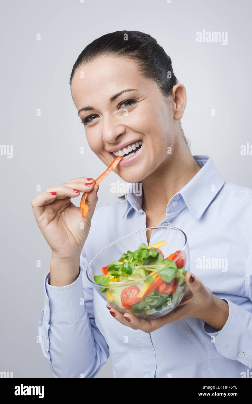 Cheerful woman eating salad and smiling, healthy eating concept Stock ...