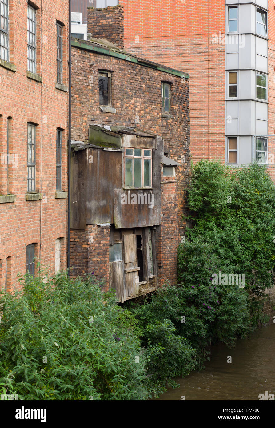 Rear of derelict houses with former toilets overhanging waterway ...