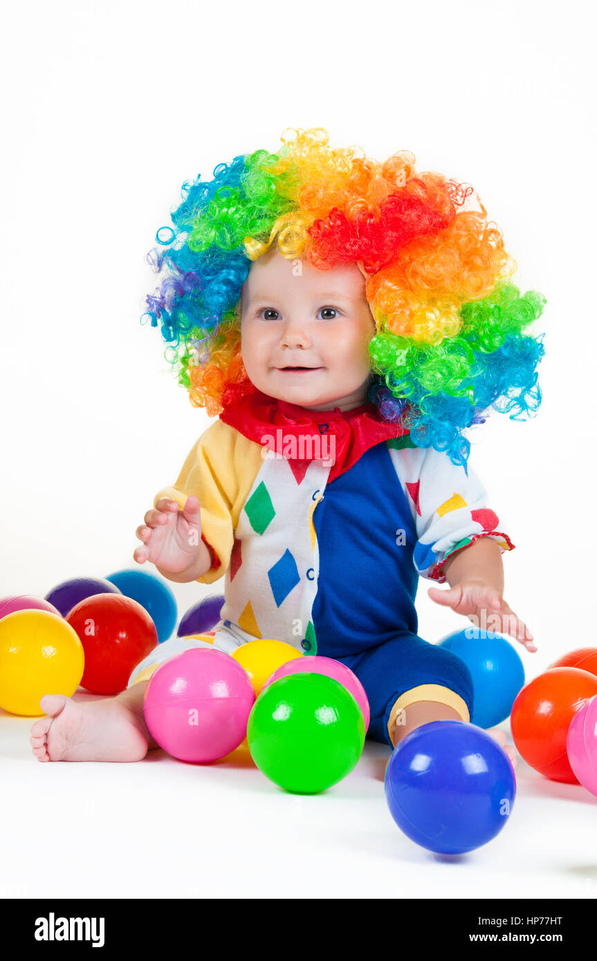 Child clown with a red nose multicolored wig in with balls Stock Photo ...