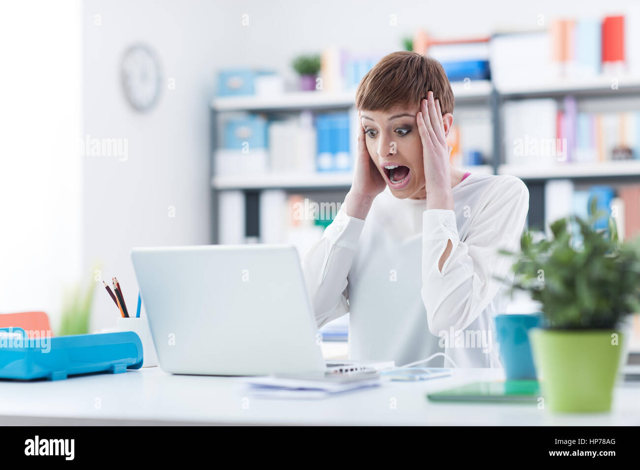 Shocked woman with head in hands having computer problems, she is ...